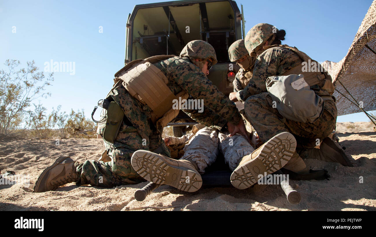 Hospital corpsmen and Marines check a simulated casualty and remove ...