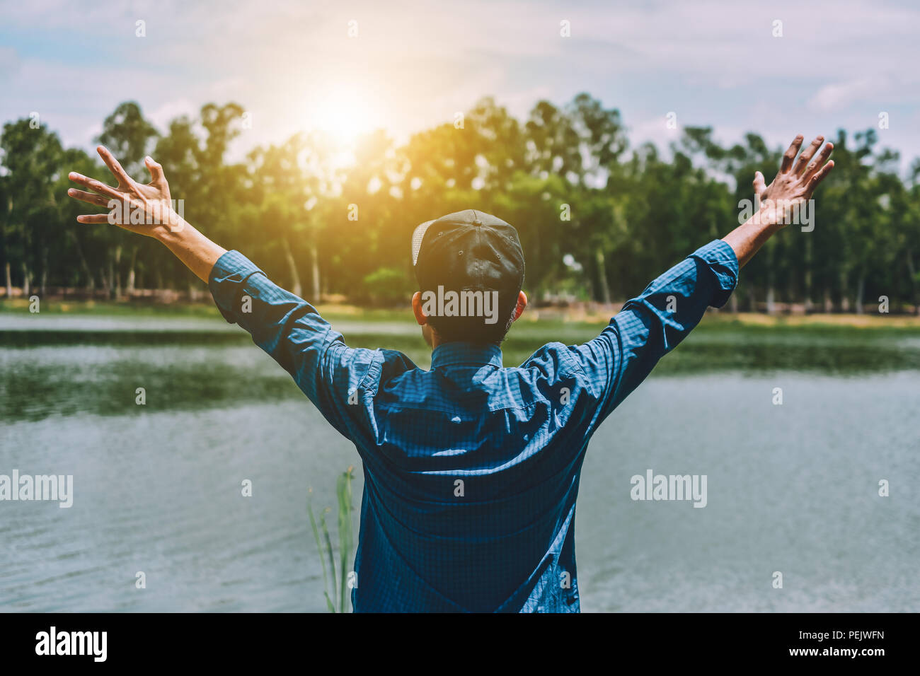 Man standing at river sunlight background Stock Photo - Alamy