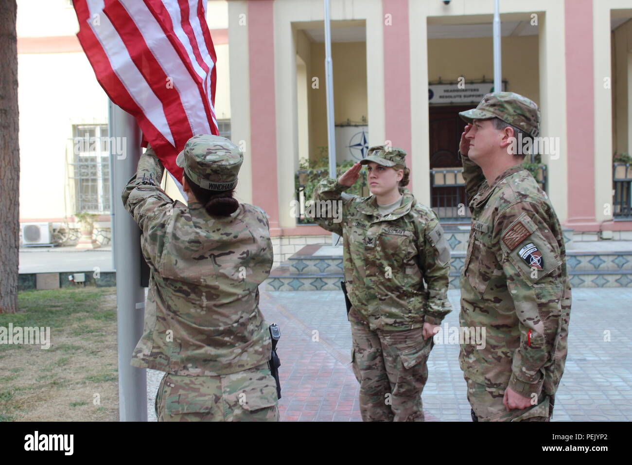 Yeoman 2nd Class Jordan Guevara, center, salutes a flag flown in honor ...