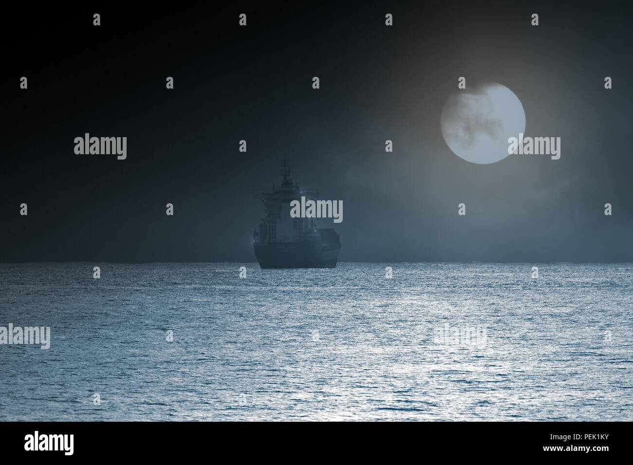 Commercial ship navigating in a full moon night Stock Photo - Alamy