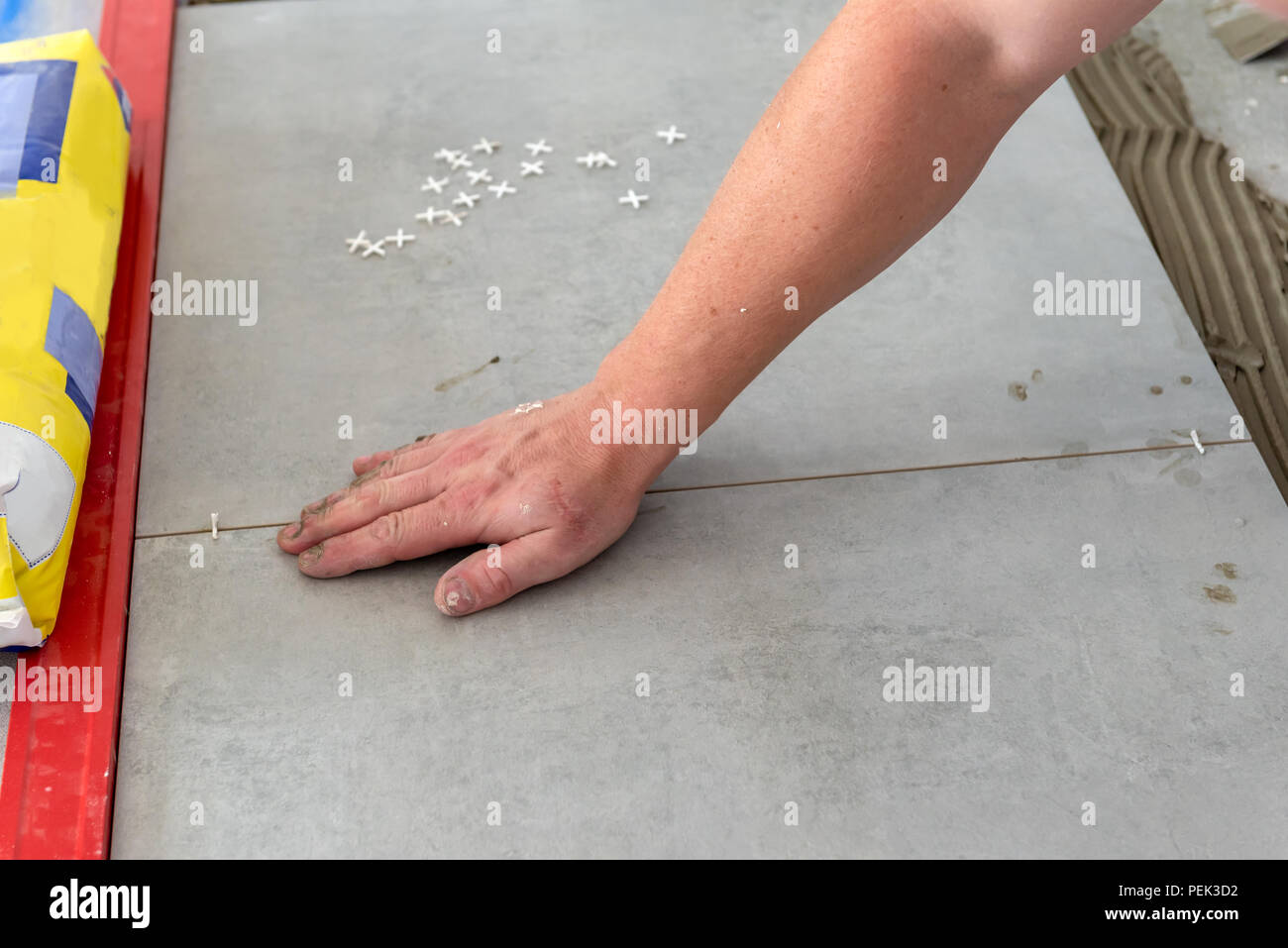 The hands of the tiler are laying the ceramic tile on the floor Stock ...