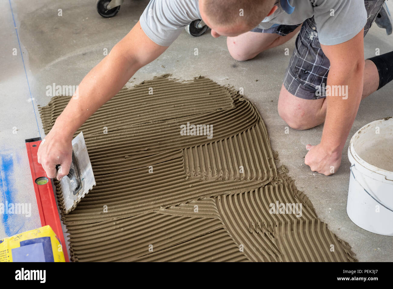The hands of the tiler are laying the ceramic tile on the floor Stock ...