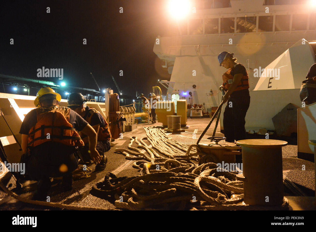 Crew members from Coast Guard Cutter Stratton heave mooring lines on ...