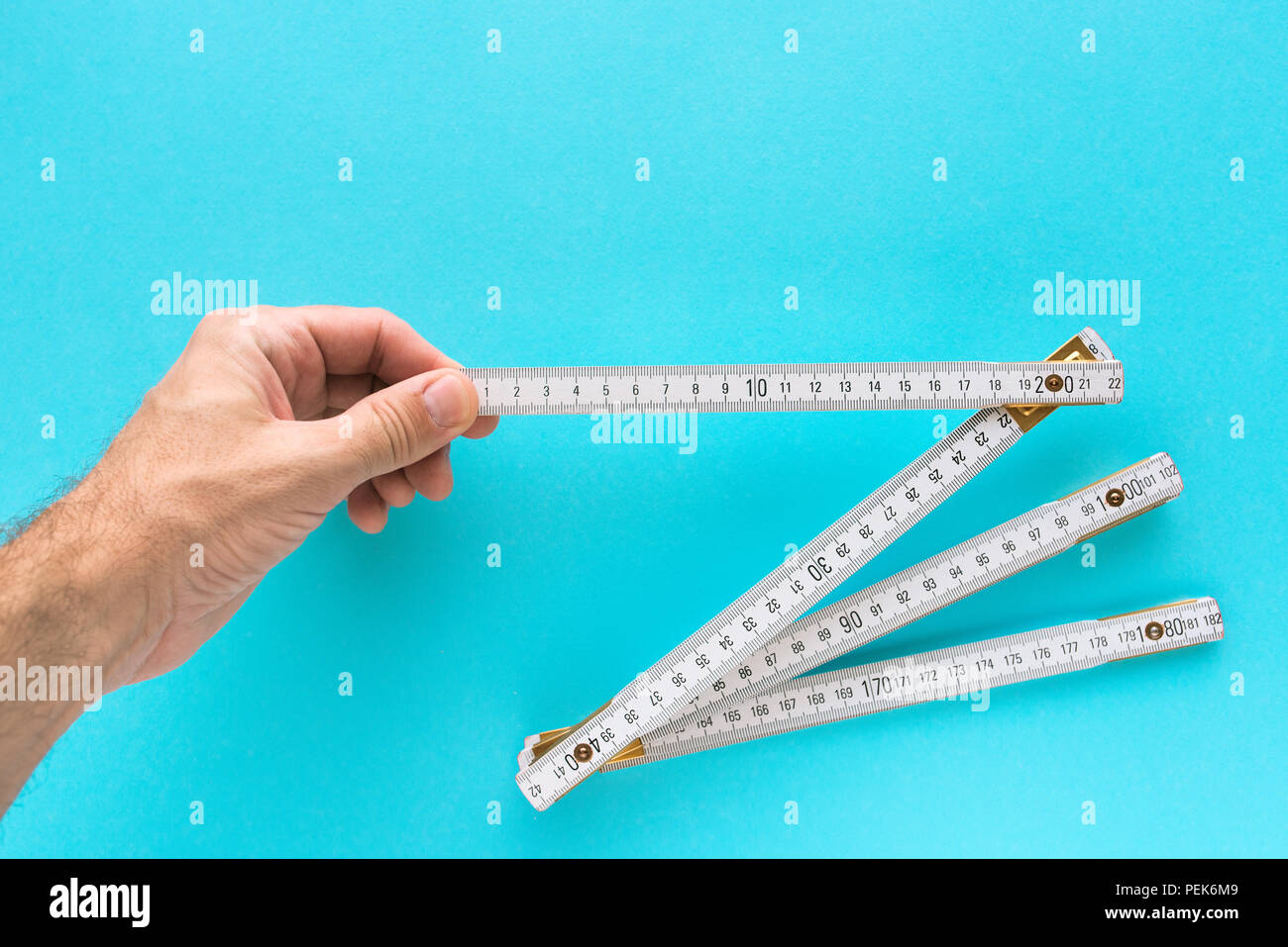 Hand holding folding ruler, overhead shot of carpenter using measuring ...