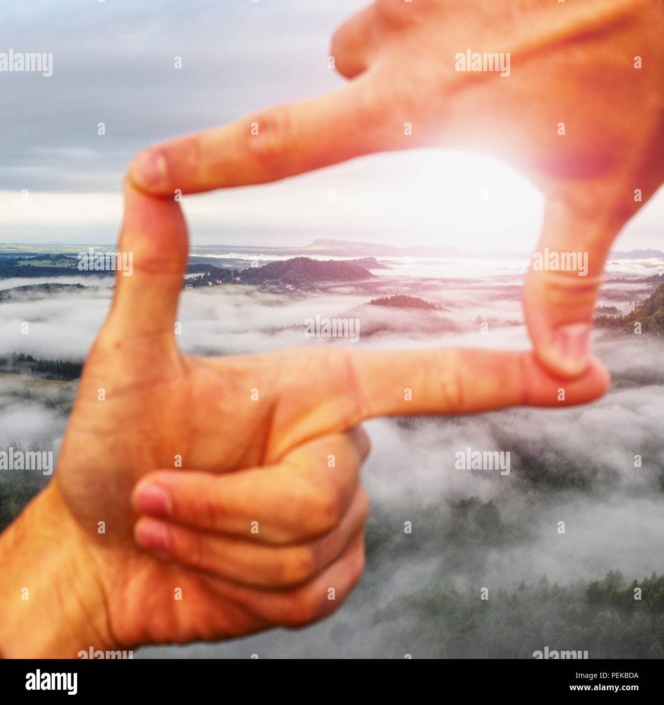 Male caucasian hands isolated at fairy landscape and sky. Hiker palms ...