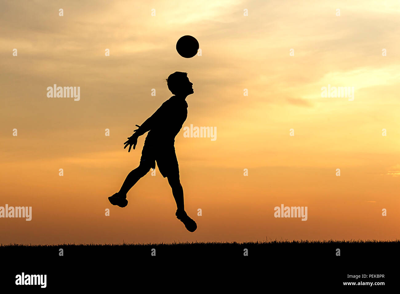 Boy playing soccer in sunset hi-res stock photography and images - Alamy
