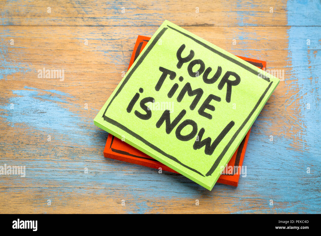 Your time is now reminder - handwriting on a sticky note against grunge ...