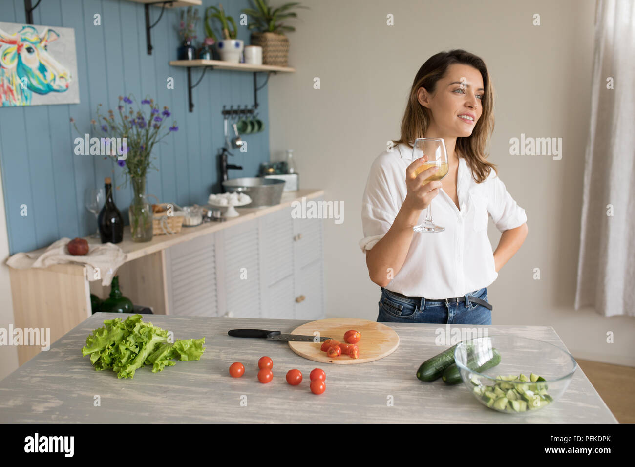 Woman drinking wine while cooking in the kitchen Stock Photo - Alamy