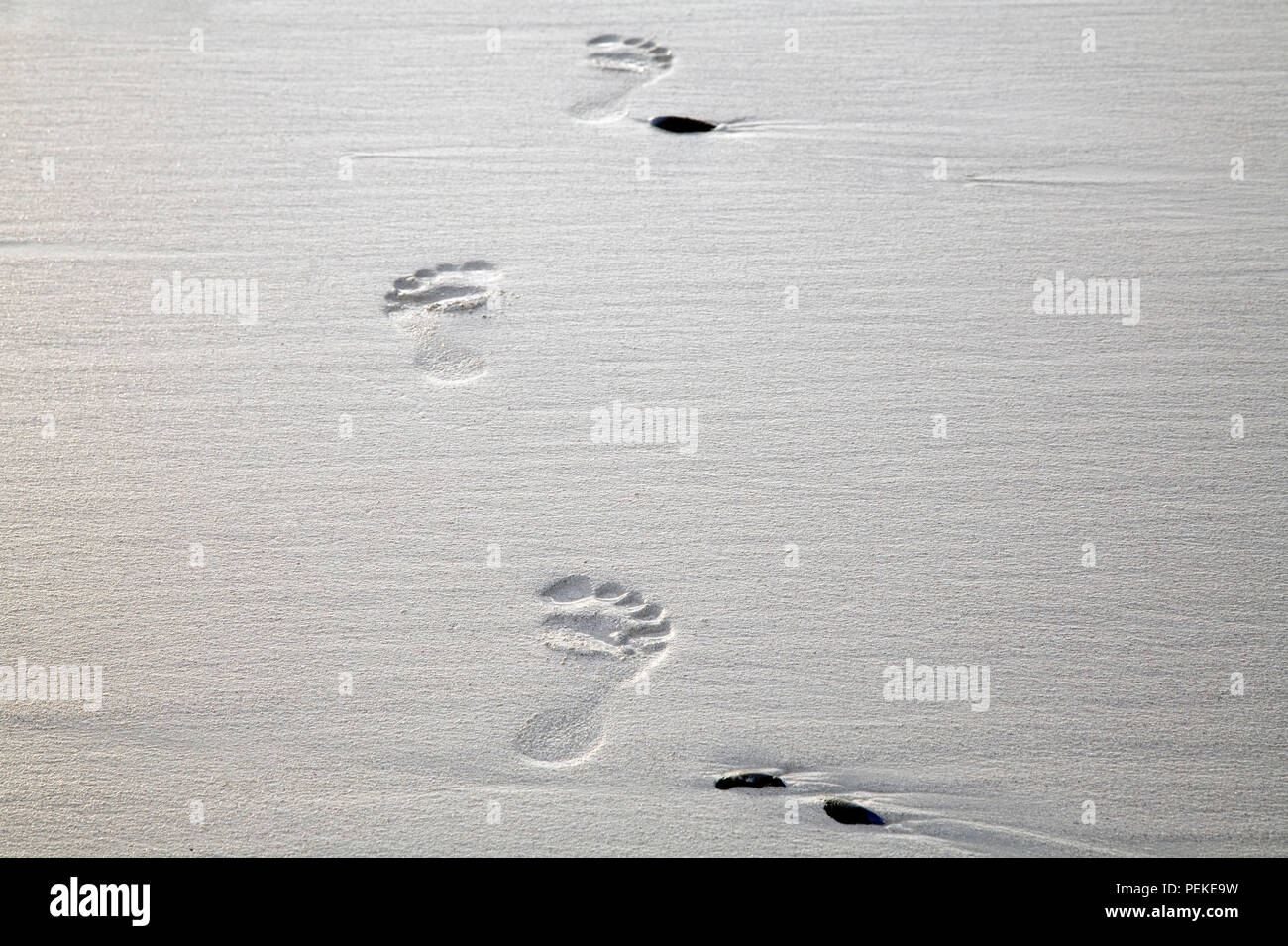 Three footsteps in the sand Stock Photo - Alamy