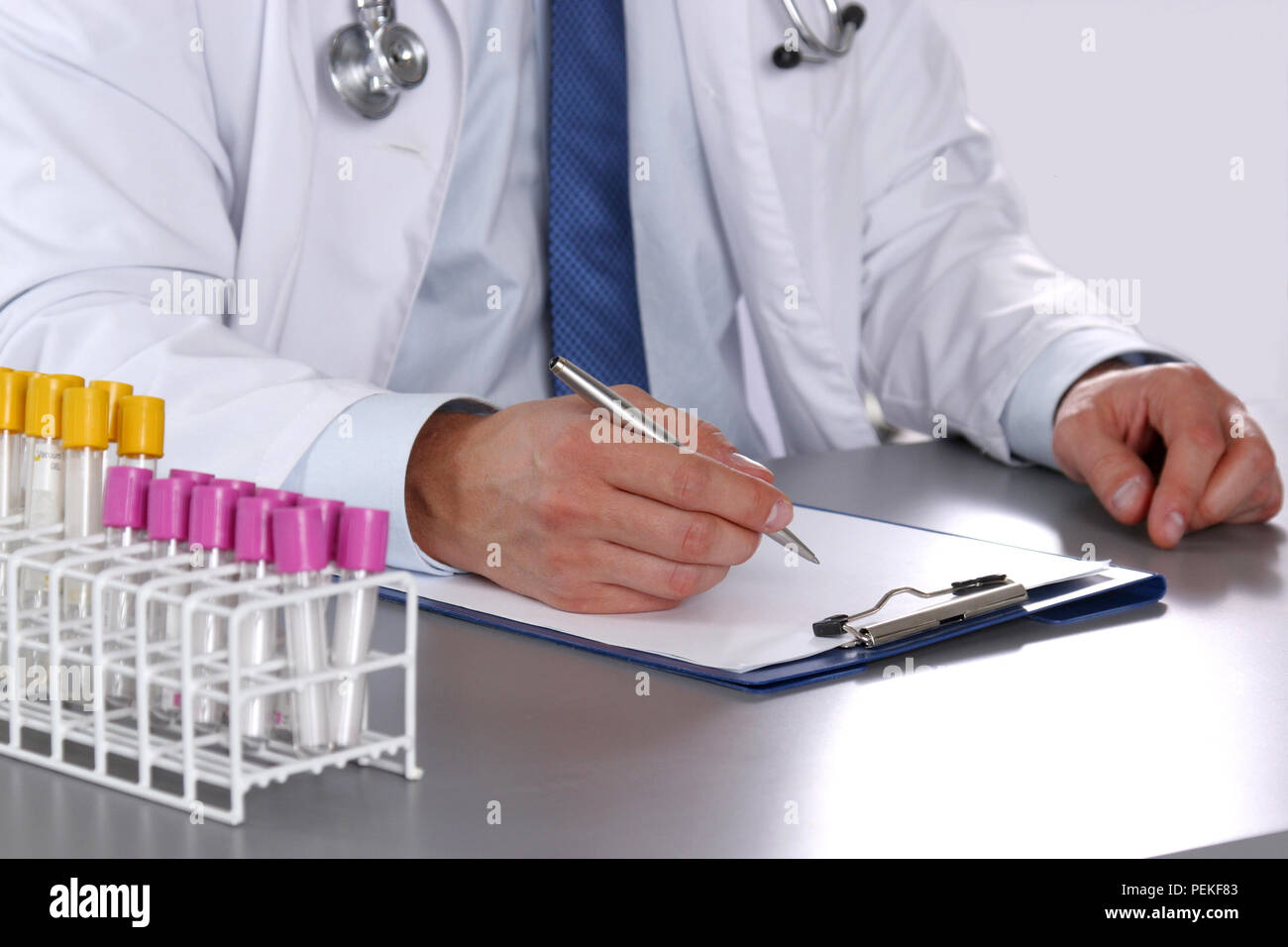 Male doctor write on the desk with test tube Stock Photo - Alamy