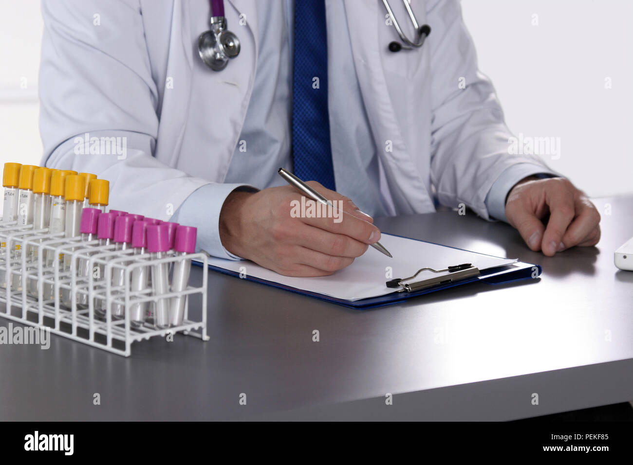 Male doctor write on the desk with test tube Stock Photo - Alamy