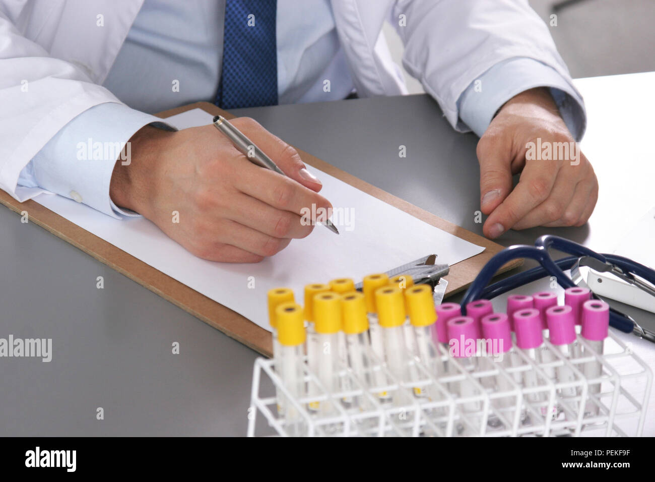 Male doctor write on the desk with test tube Stock Photo - Alamy
