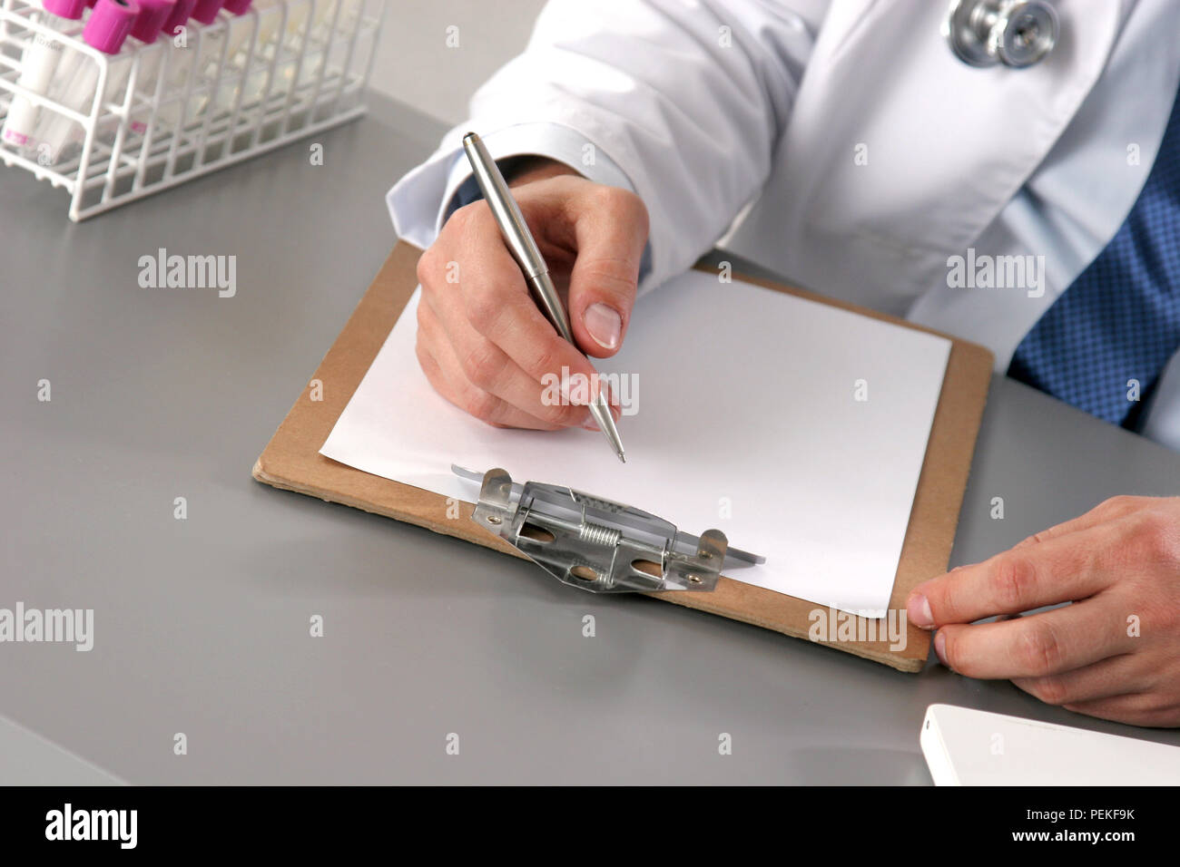 Male doctor write on the desk with test tube Stock Photo - Alamy