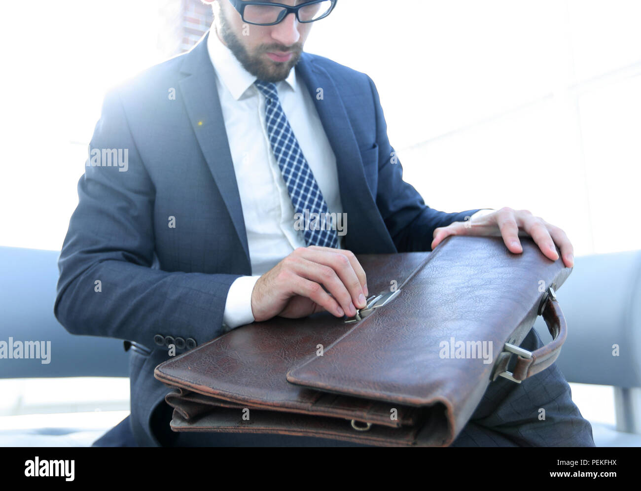 businessman's hand with suitecase in a modern office Stock Photo - Alamy
