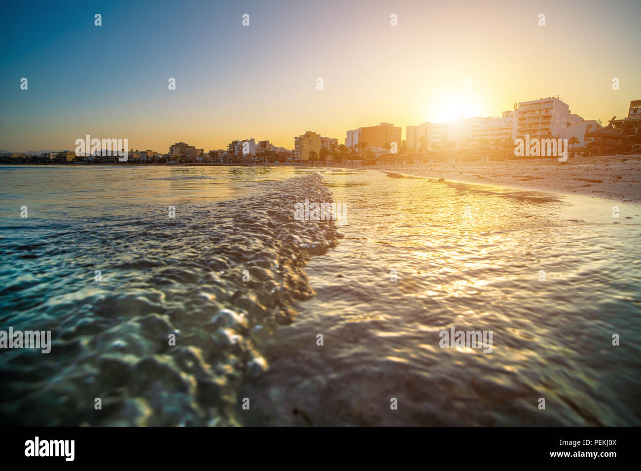 Wavy curves of sea is covered in golden sunset light. Sea at sunset ...