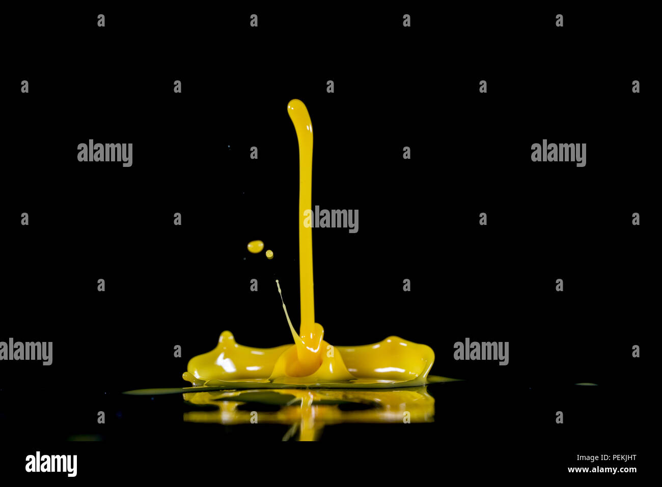 Yellow paint, ink splash on black background Stock Photo - Alamy