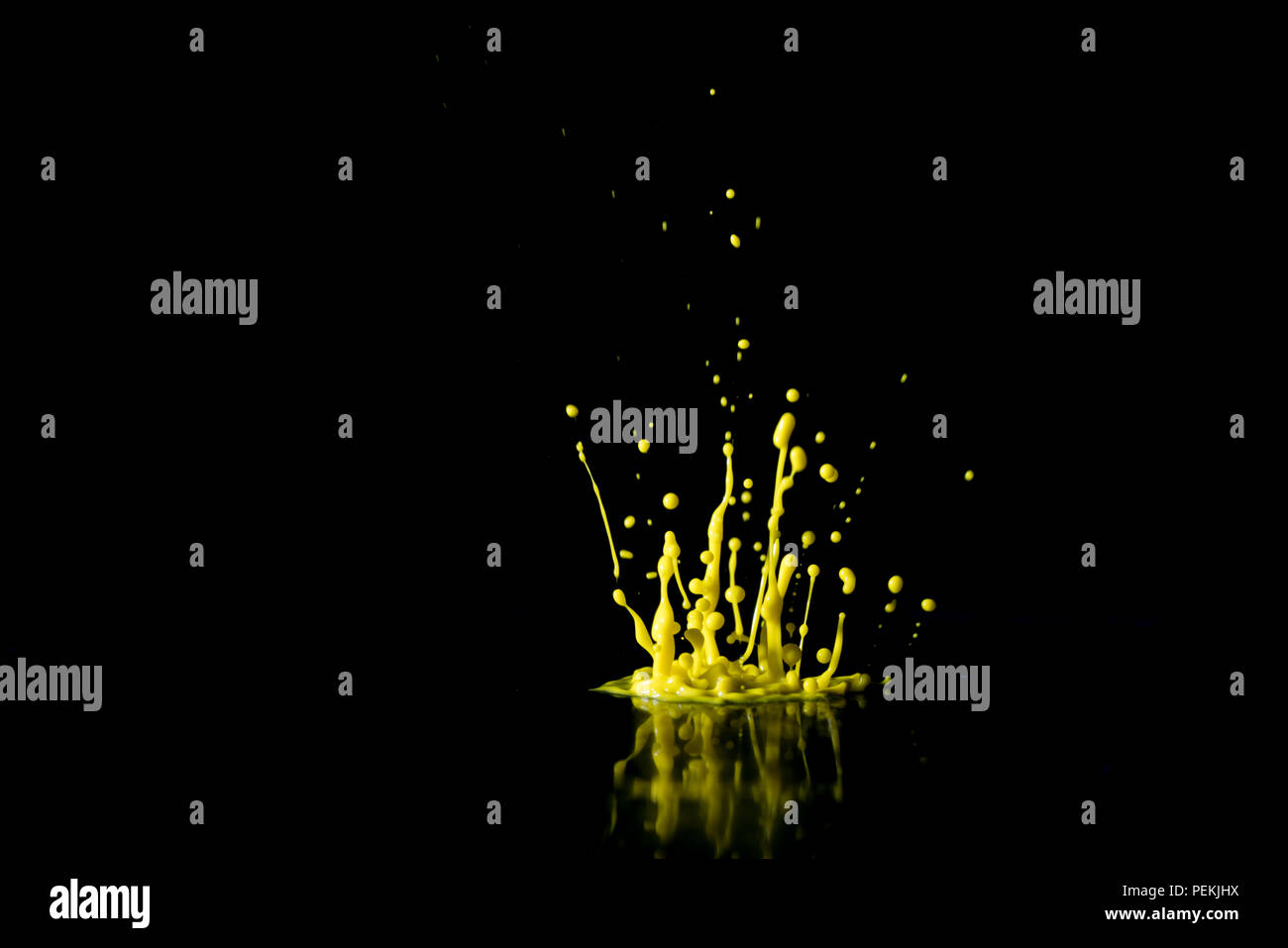 Yellow paint, ink splash on black background Stock Photo - Alamy
