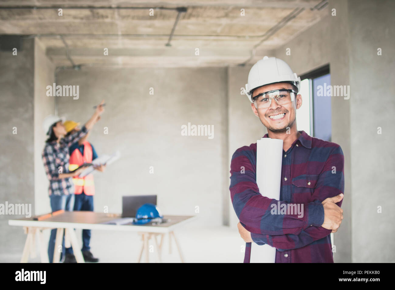 portrait engineer holding blueprint in construction site with architect ...