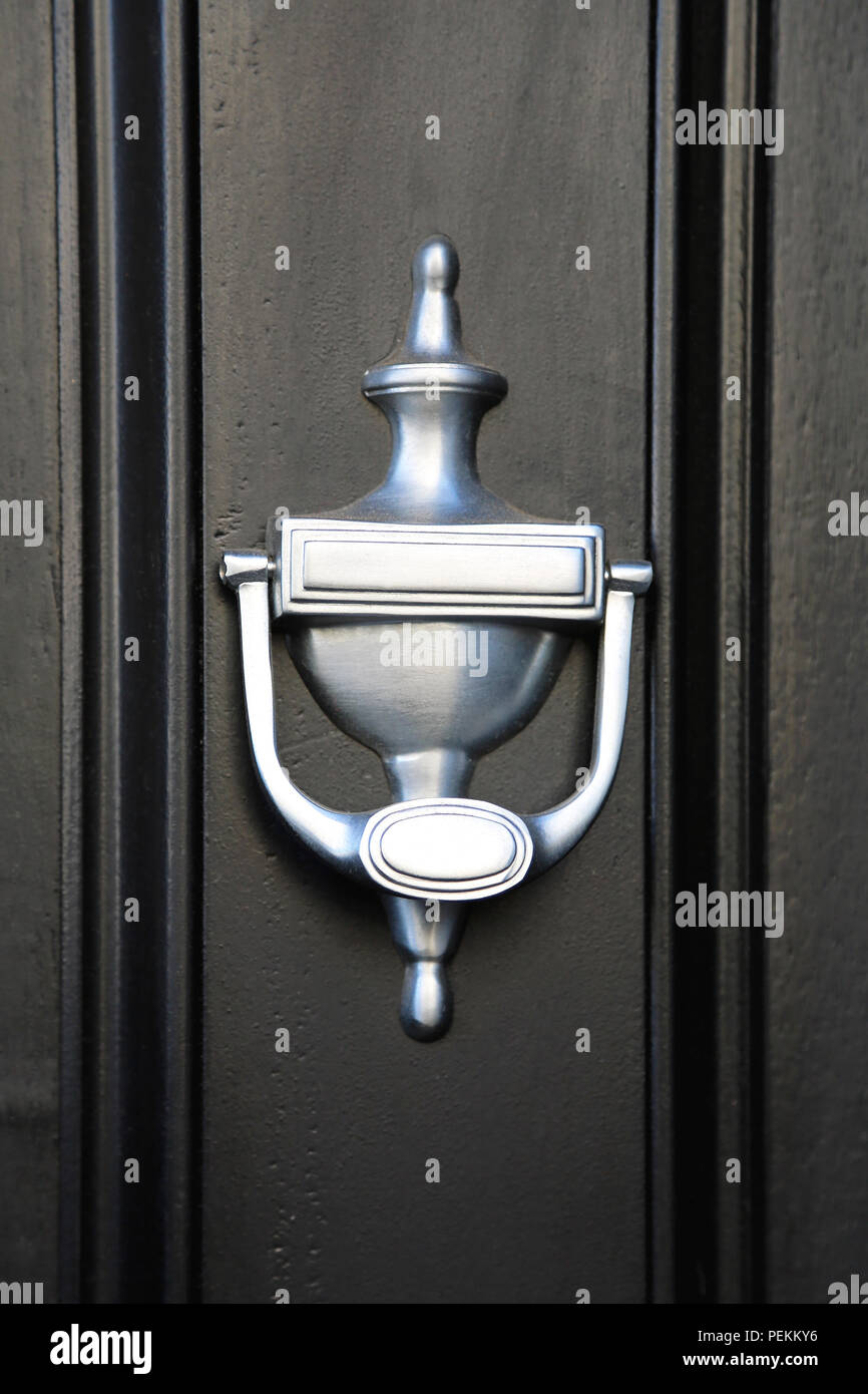 Modern silver knocker at black door Stock Photo - Alamy
