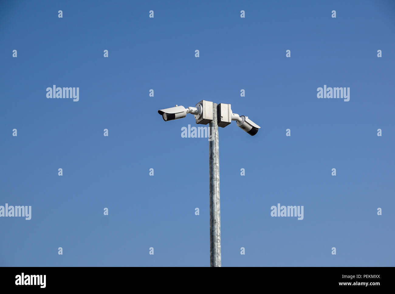 CCTV surveillance security camera on a black pole with blue sky ...