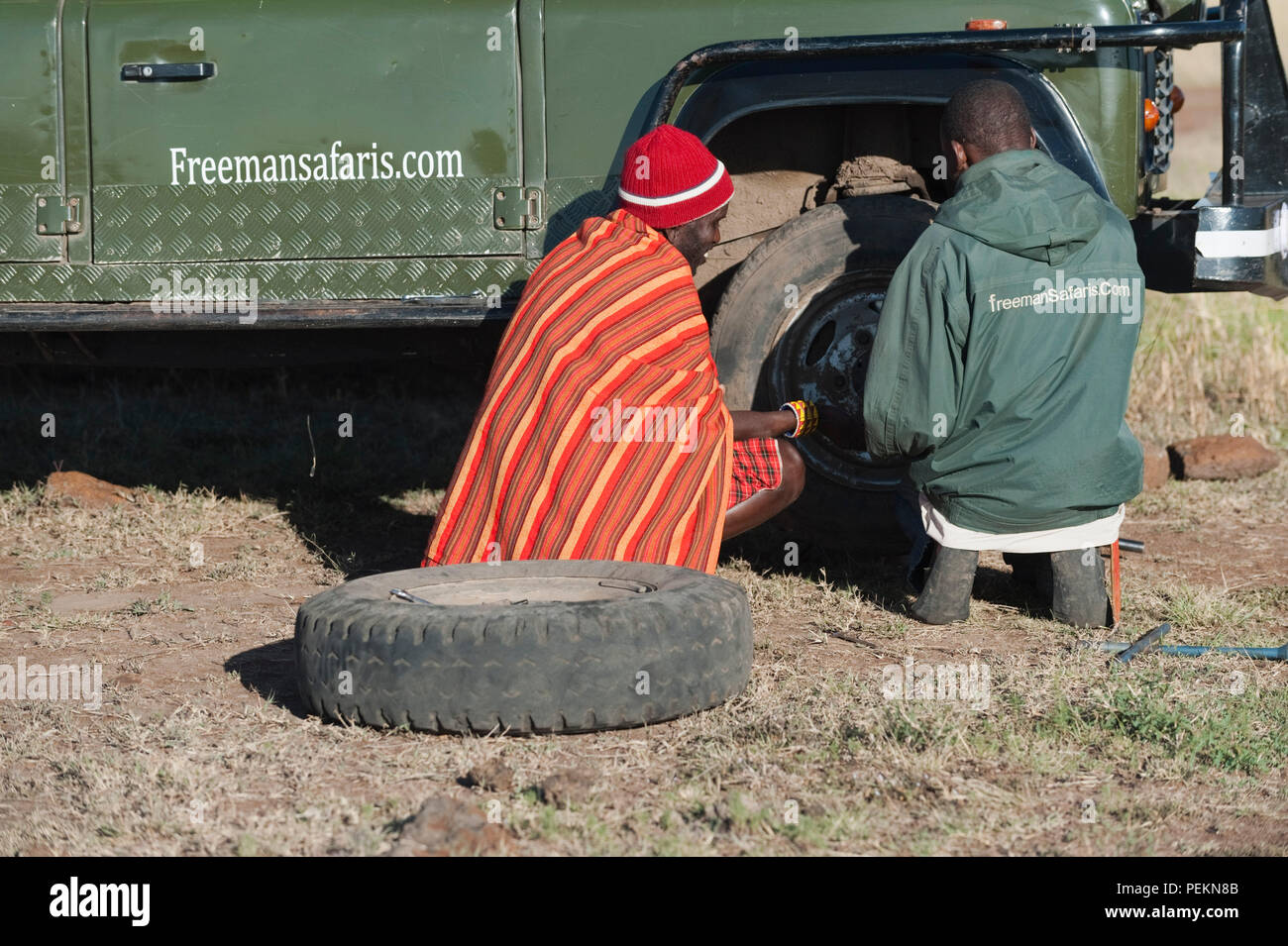 Changing a flat tyre on a Jeep in the Masai Mara Kenya Stock Photo - Alamy