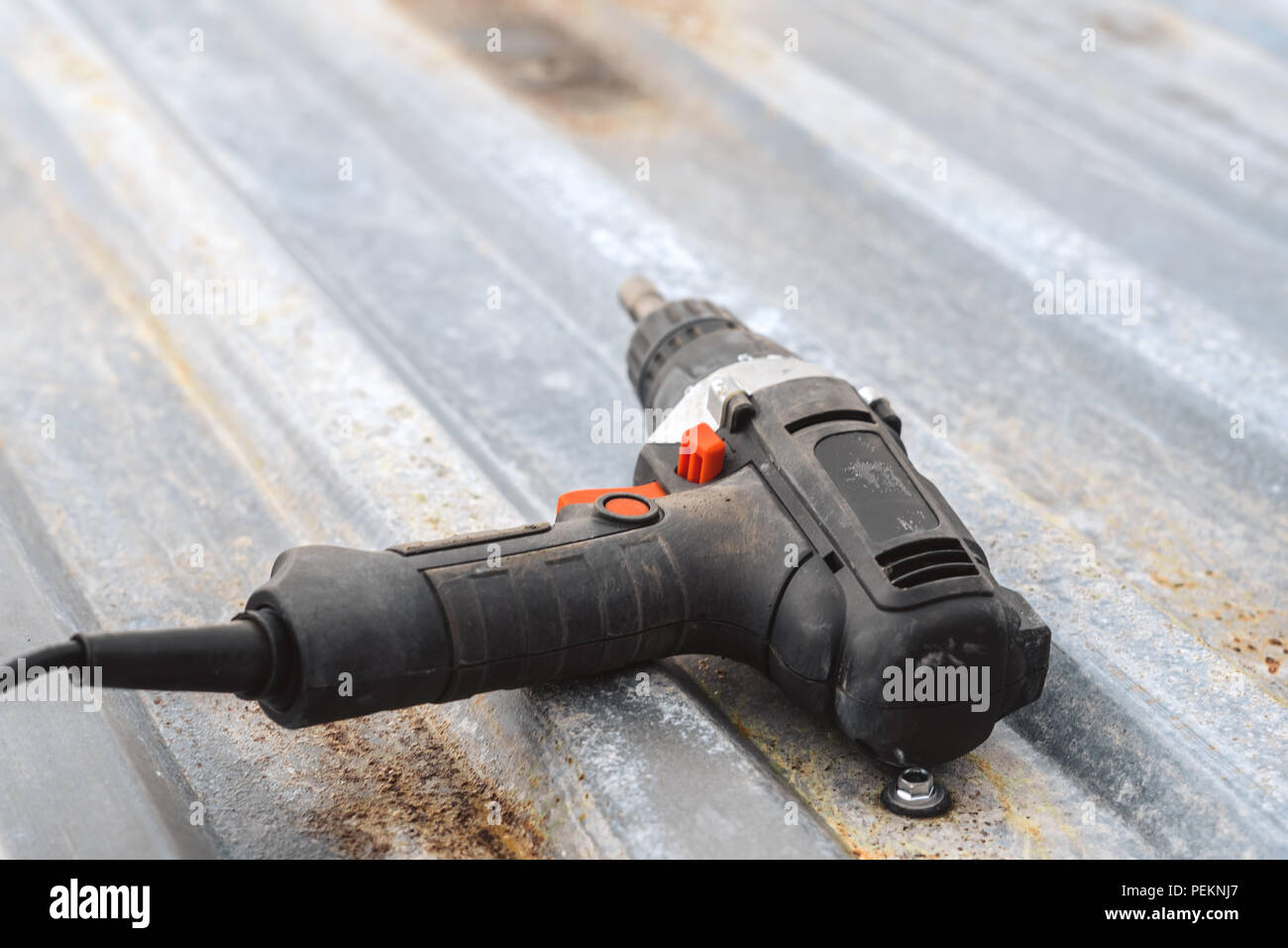 a power drill lying on the metal roofing Stock Photo - Alamy