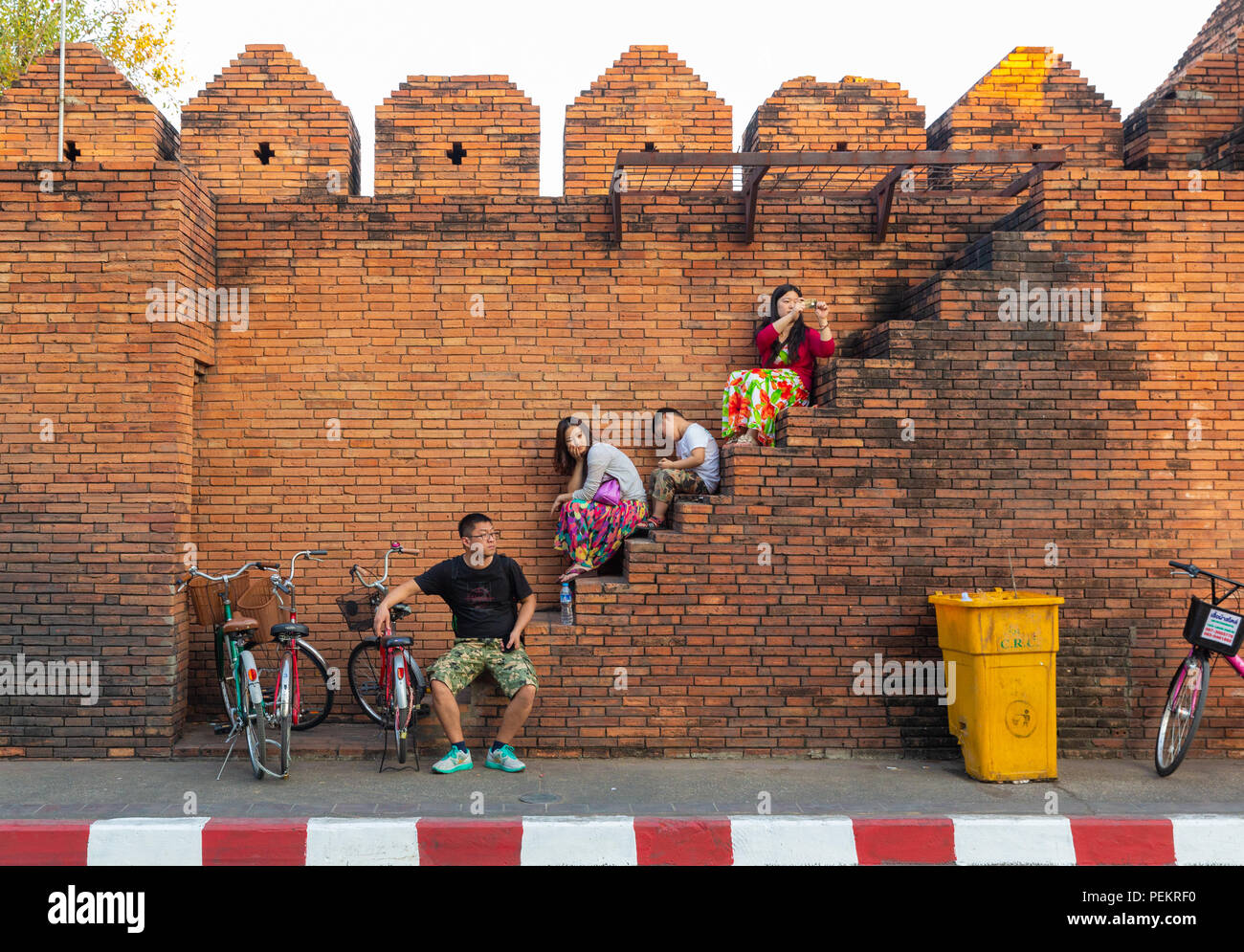 People (presumably a tourist family) sitting on steps at the ancient ...