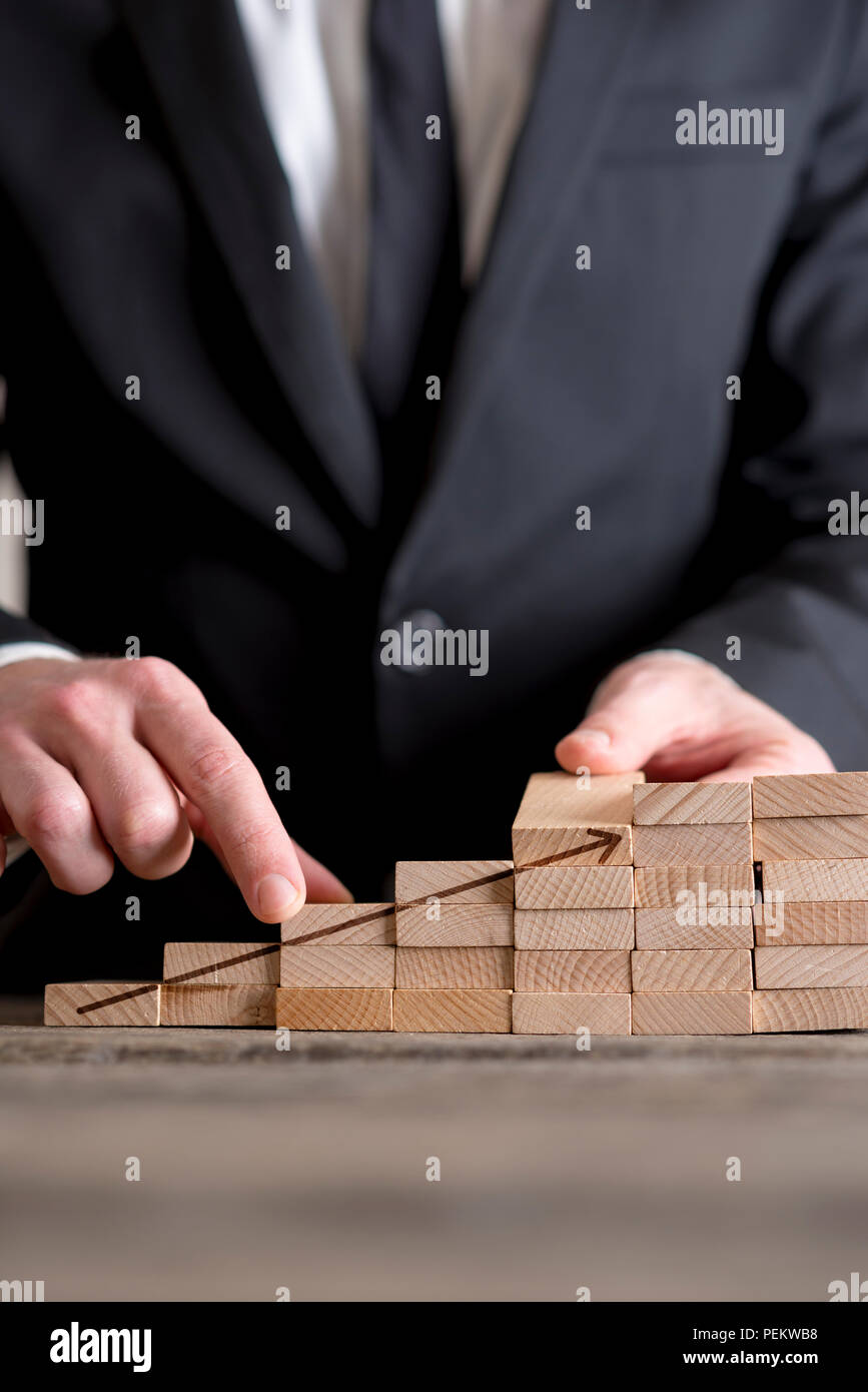 Vertical close-up of businessman building career ladder stairs or ... Vertical close-up of businessman building career ladder stairs or ...
