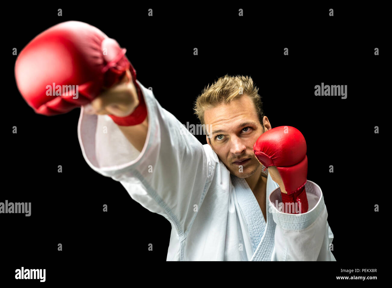 Caucasian kickboxer with red boxing gloves performing a martial arts ...