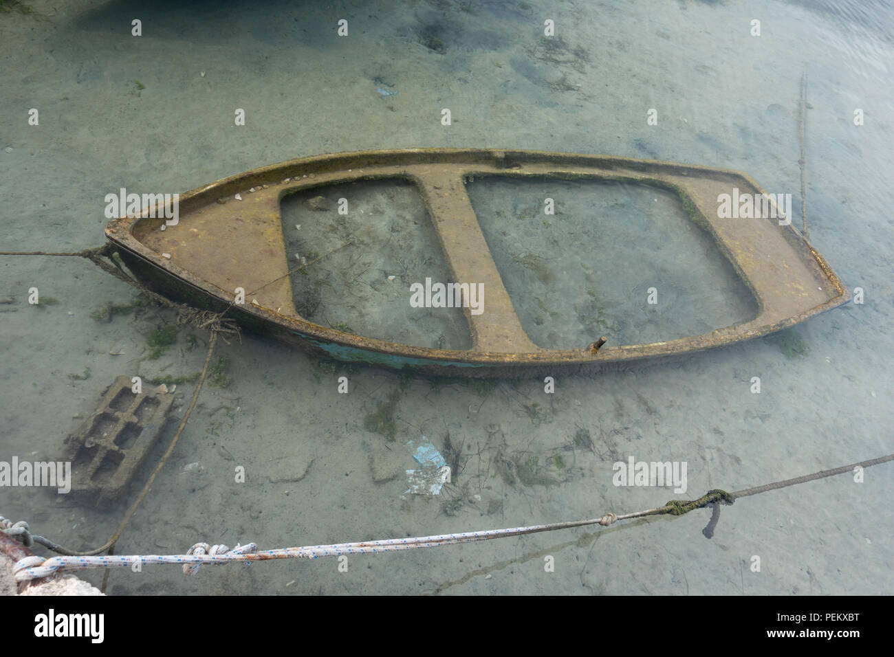 Small sunken boat in harbor submerged in shallow water and moored Stock ...