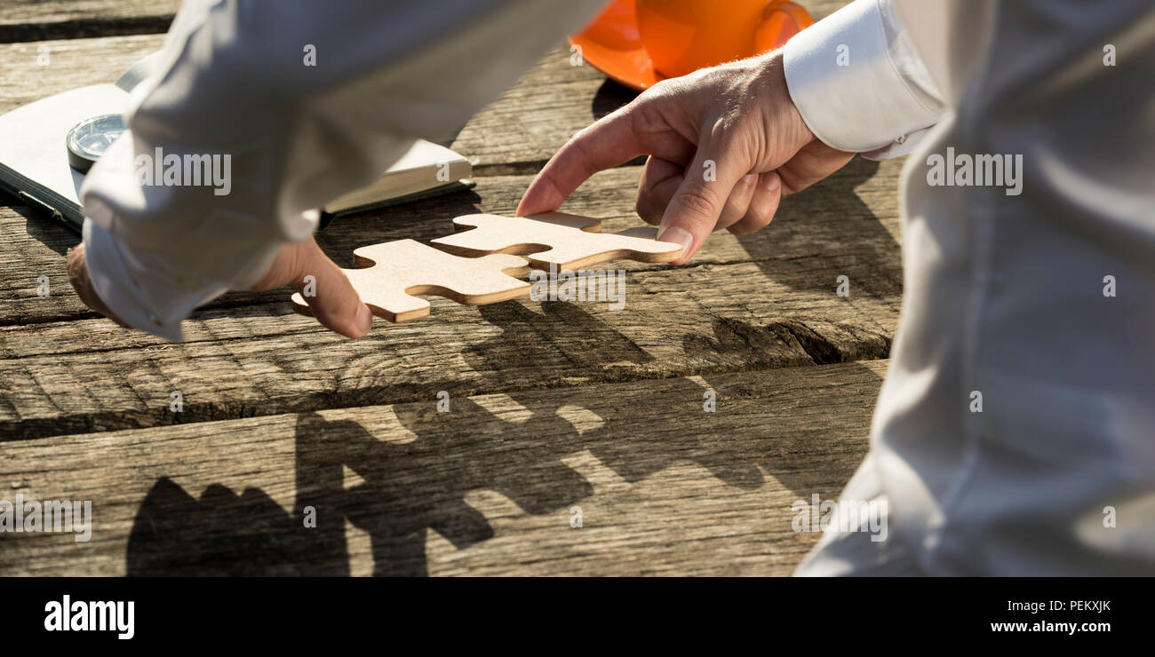 Rear view close-up of the hands of a man putting together two ...