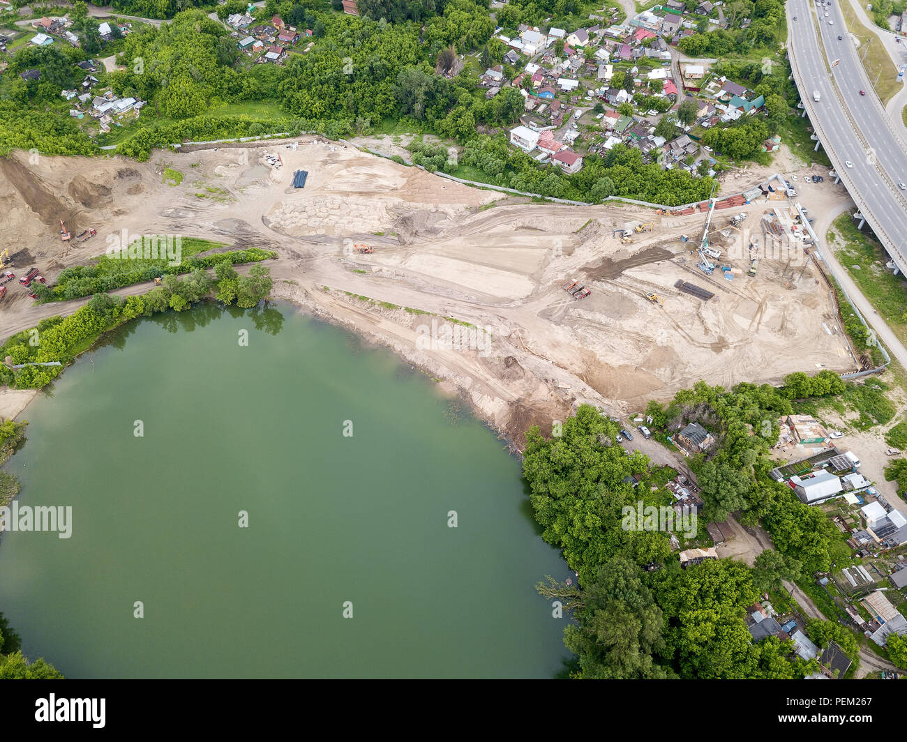 Aerial photography of a small lake with green water surrounded by trees ...