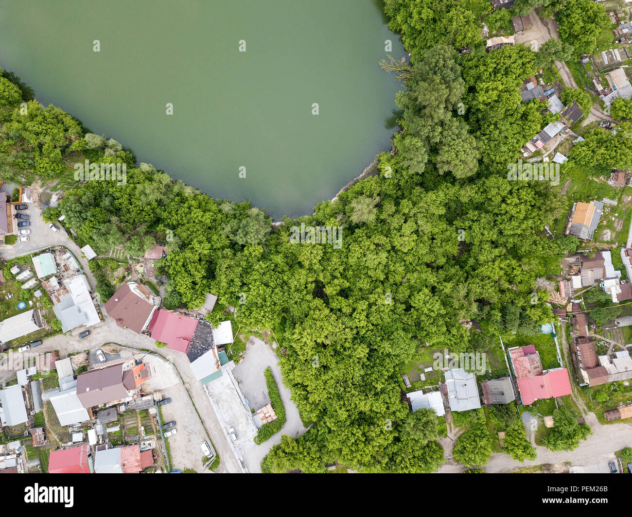 Aerial photography of a small lake with green water surrounded by trees ...