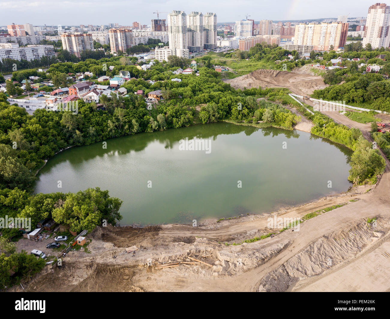 Aerial photography of a small lake with green water surrounded by trees ...