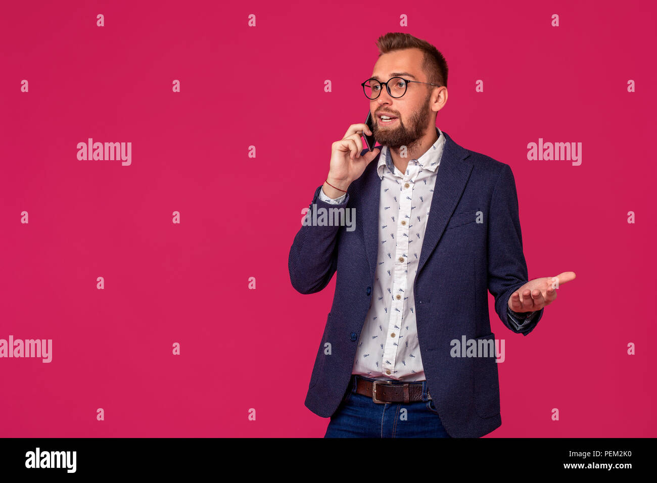 Young cheerful lawyer or businessman is standing on the pink background ...