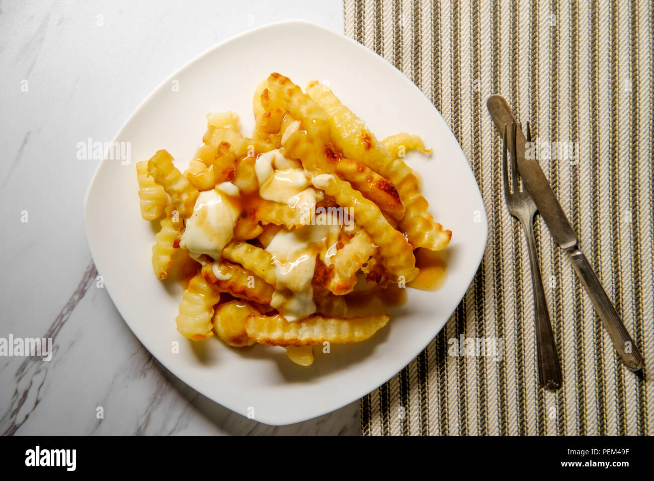 Canadian Poutine crinkle-cut fries with gravy and cheese curd Stock ...