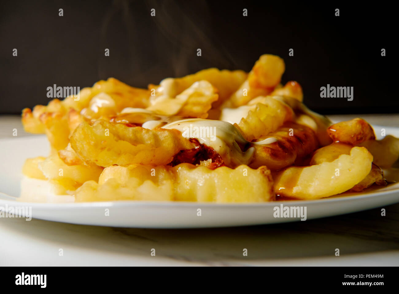 Canadian Poutine crinkle-cut fries with gravy and cheese curd Stock ...