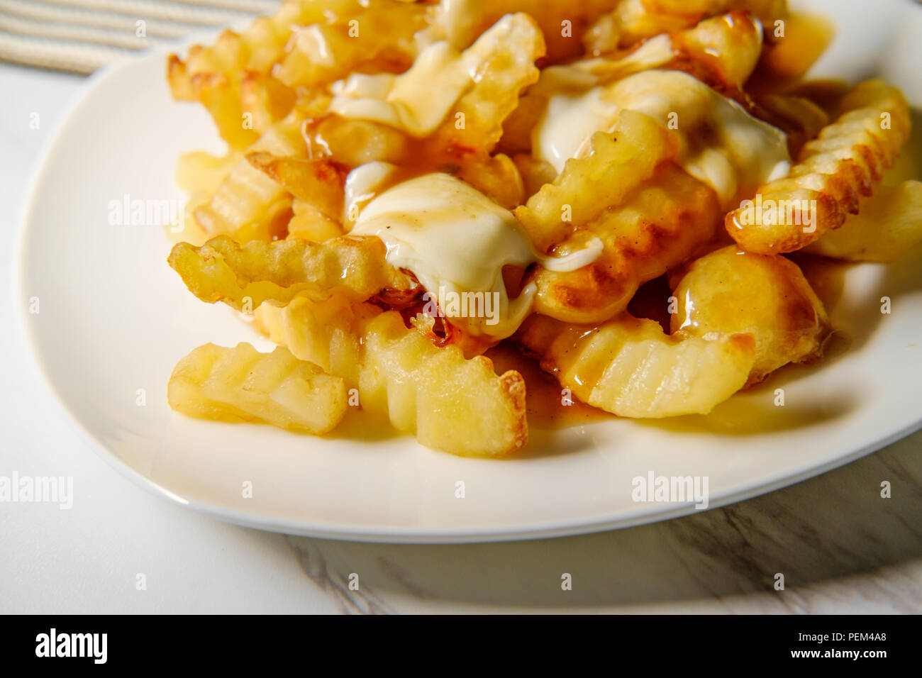 Canadian Poutine crinkle-cut fries with gravy and cheese curd Stock ...