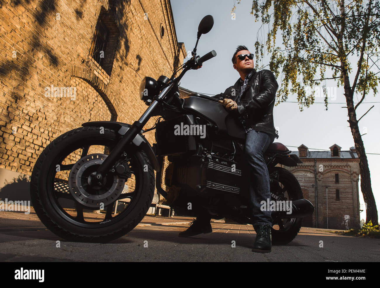 Man sitting on a cafe-racer motorcycle outdoors Stock Photo - Alamy