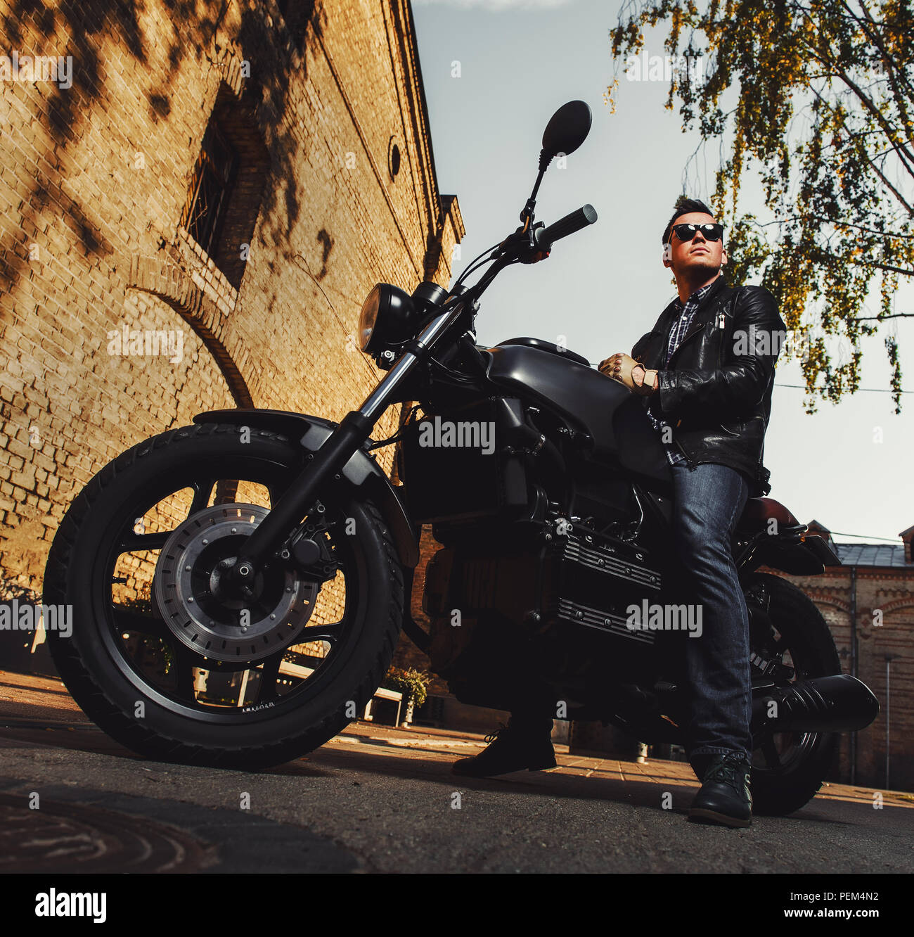 Man sitting on a cafe-racer motorcycle outdoors Stock Photo - Alamy