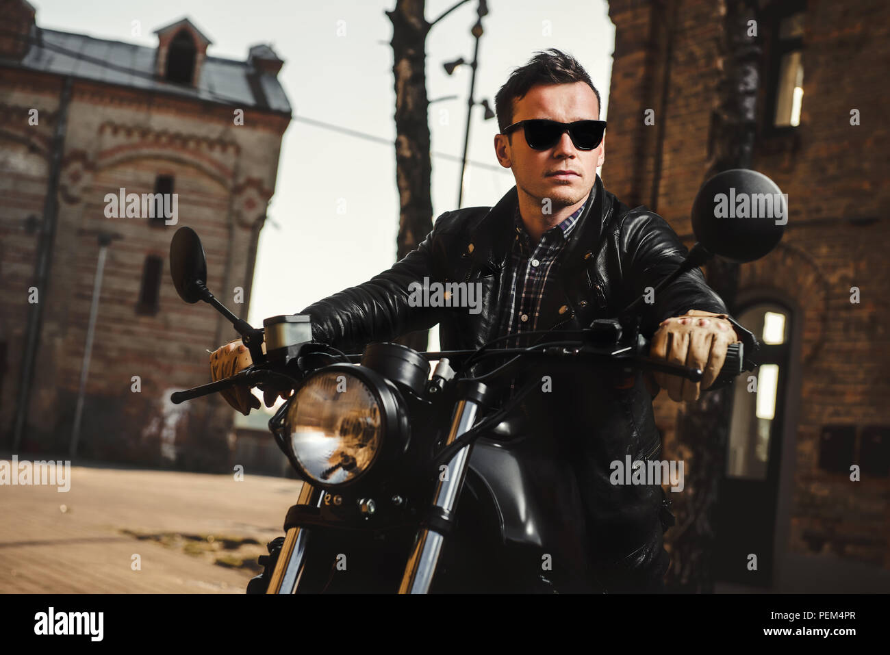 Man sitting on a cafe-racer motorcycle outdoors Stock Photo - Alamy