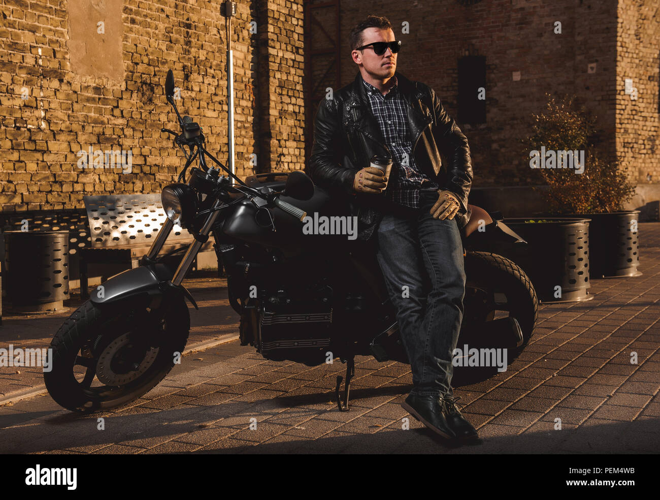 Man with a cafe-racer motorcycle outdoors Stock Photo - Alamy