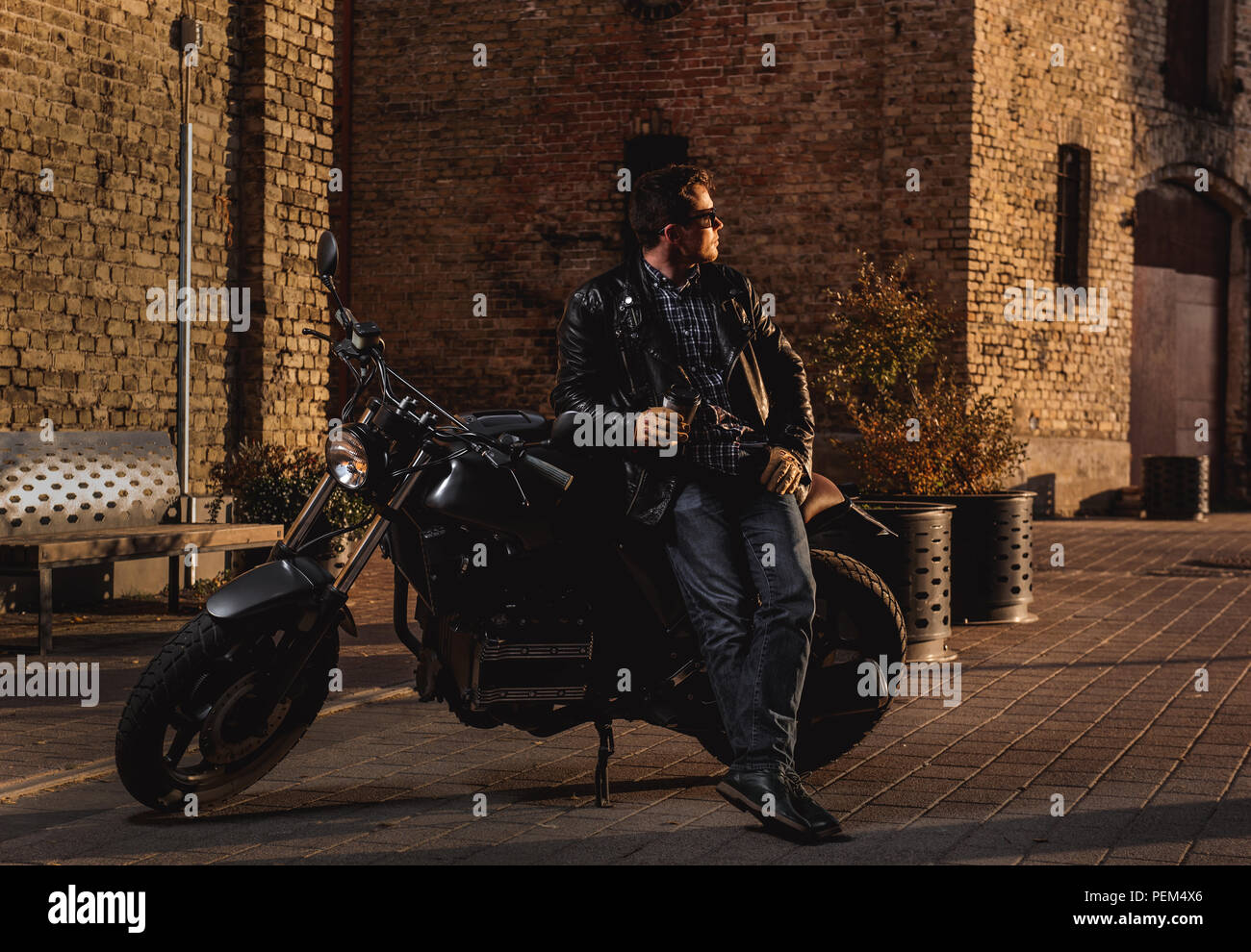 Man with a cafe-racer motorcycle outdoors Stock Photo - Alamy