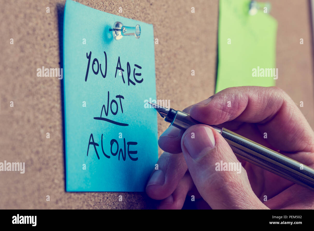 You Are Not Alone - man writing an inspirational message on a blue ...