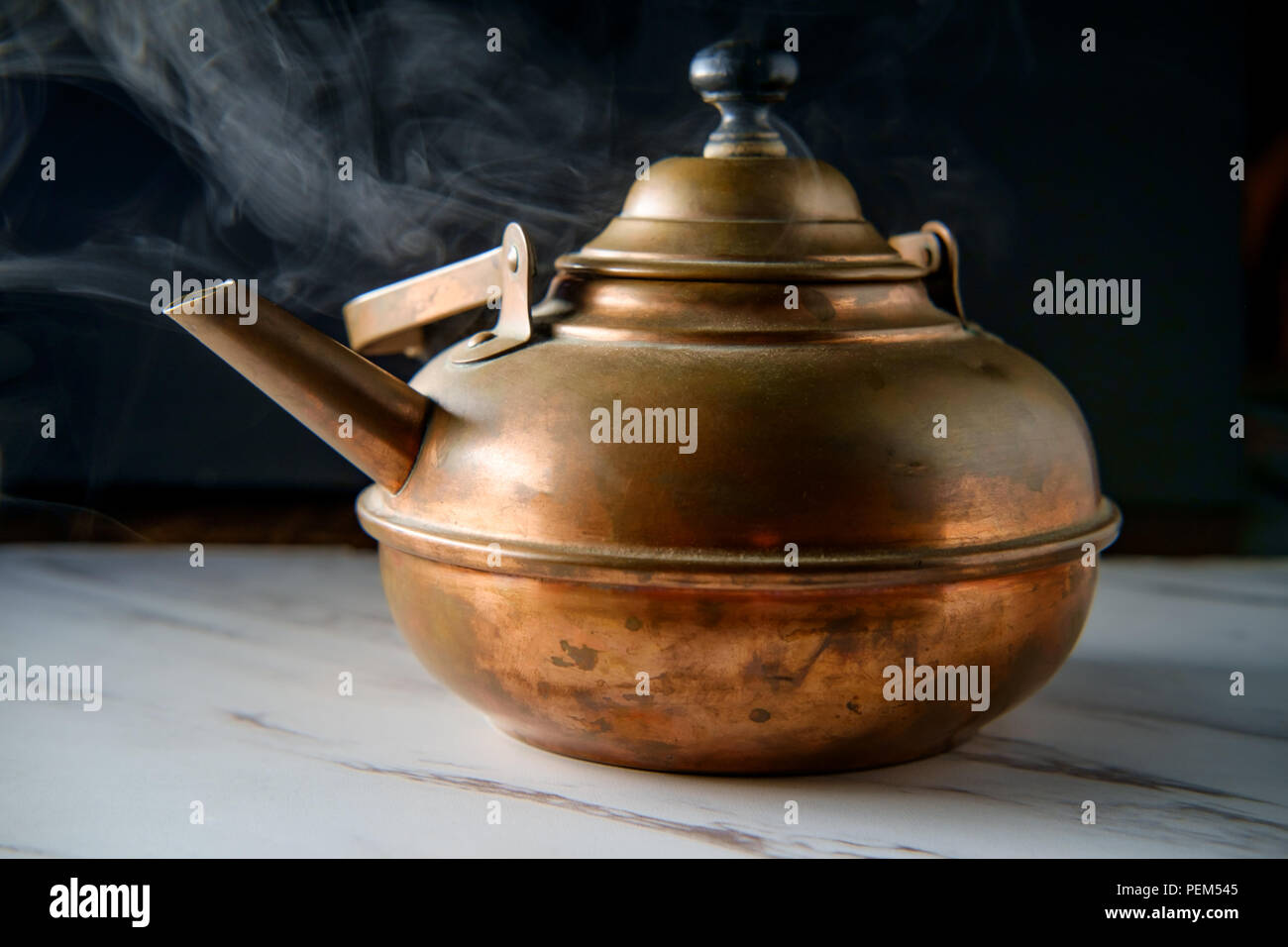 Whistling hot tea pot on kitchen counter with steam from boiled water ...