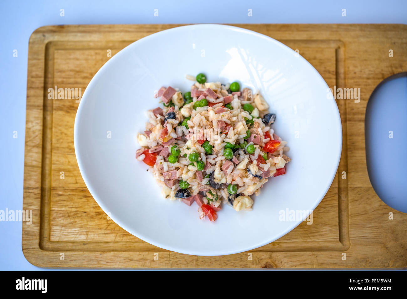 Italian rice salad or cold rice in a white plate on a chopping board ...