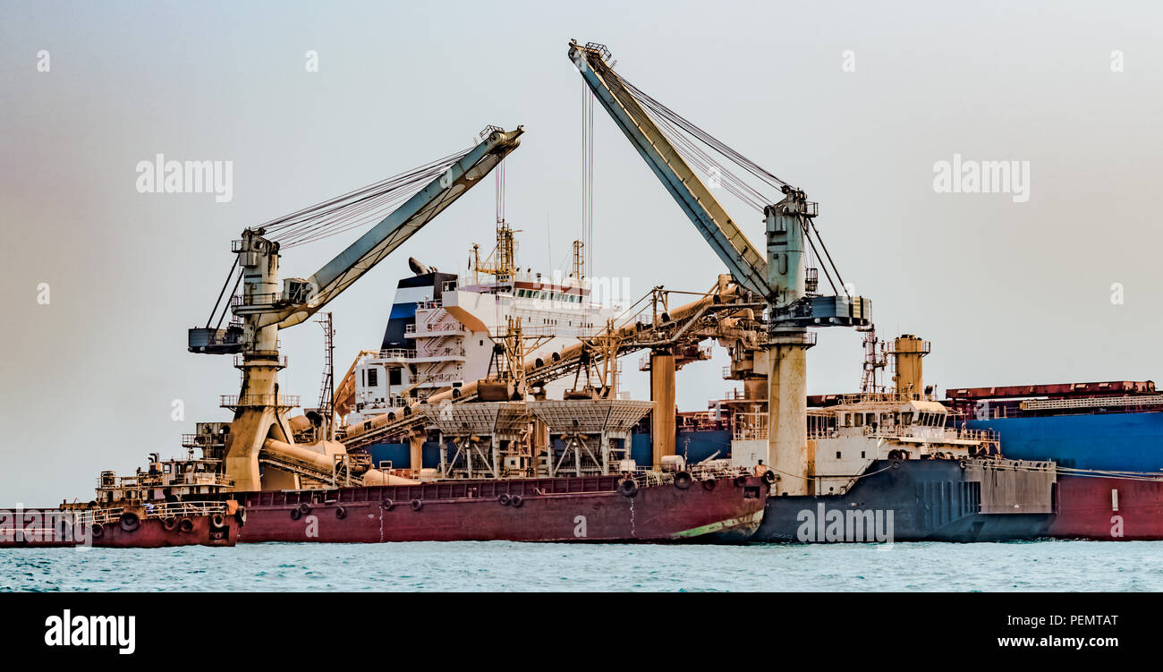 Floating Crane Transhipper anchored at high seas shifting the bulk ...