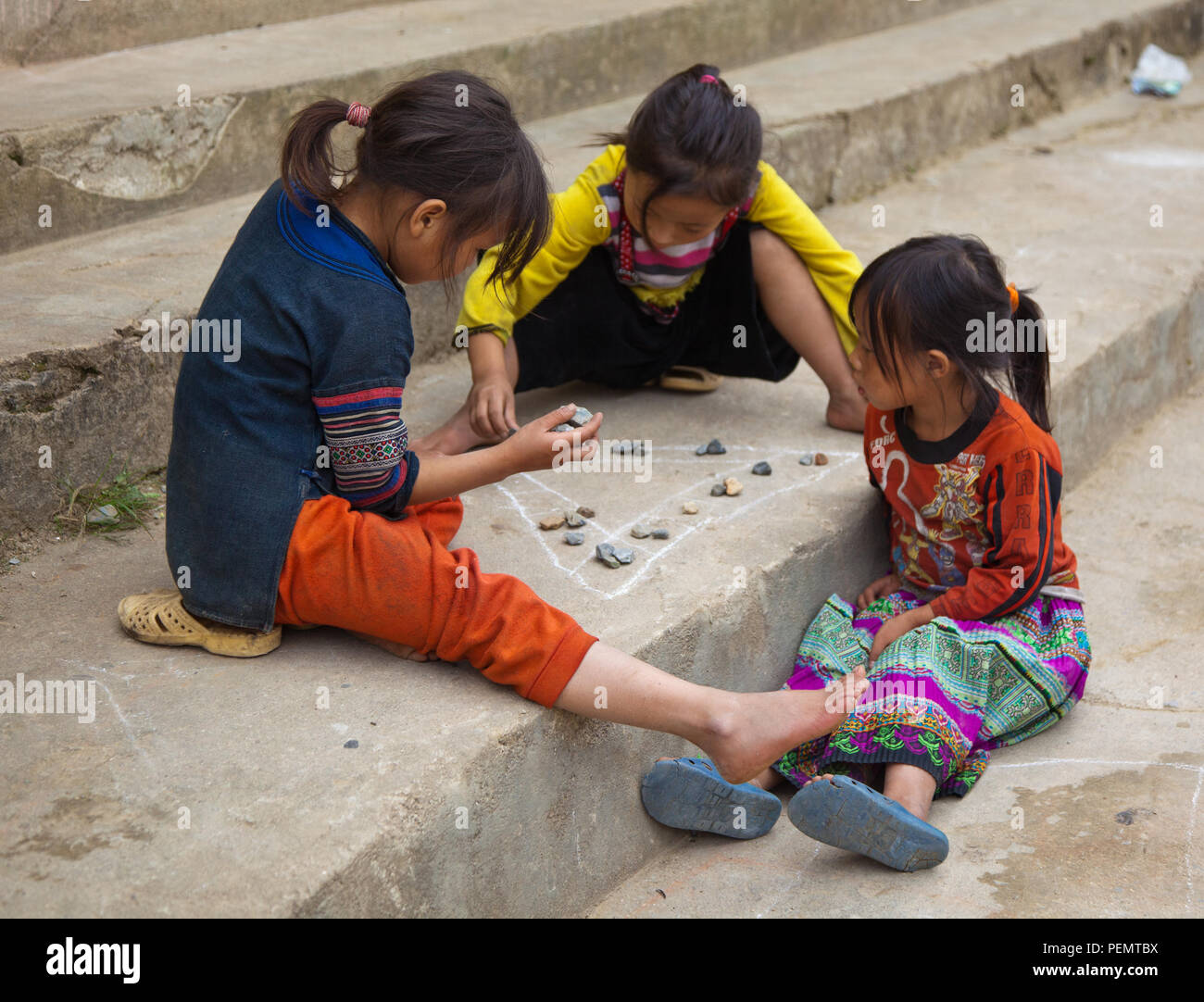 Sapa, Vietnam / Oct 22, 2011: Three girls play a game on school steps ...