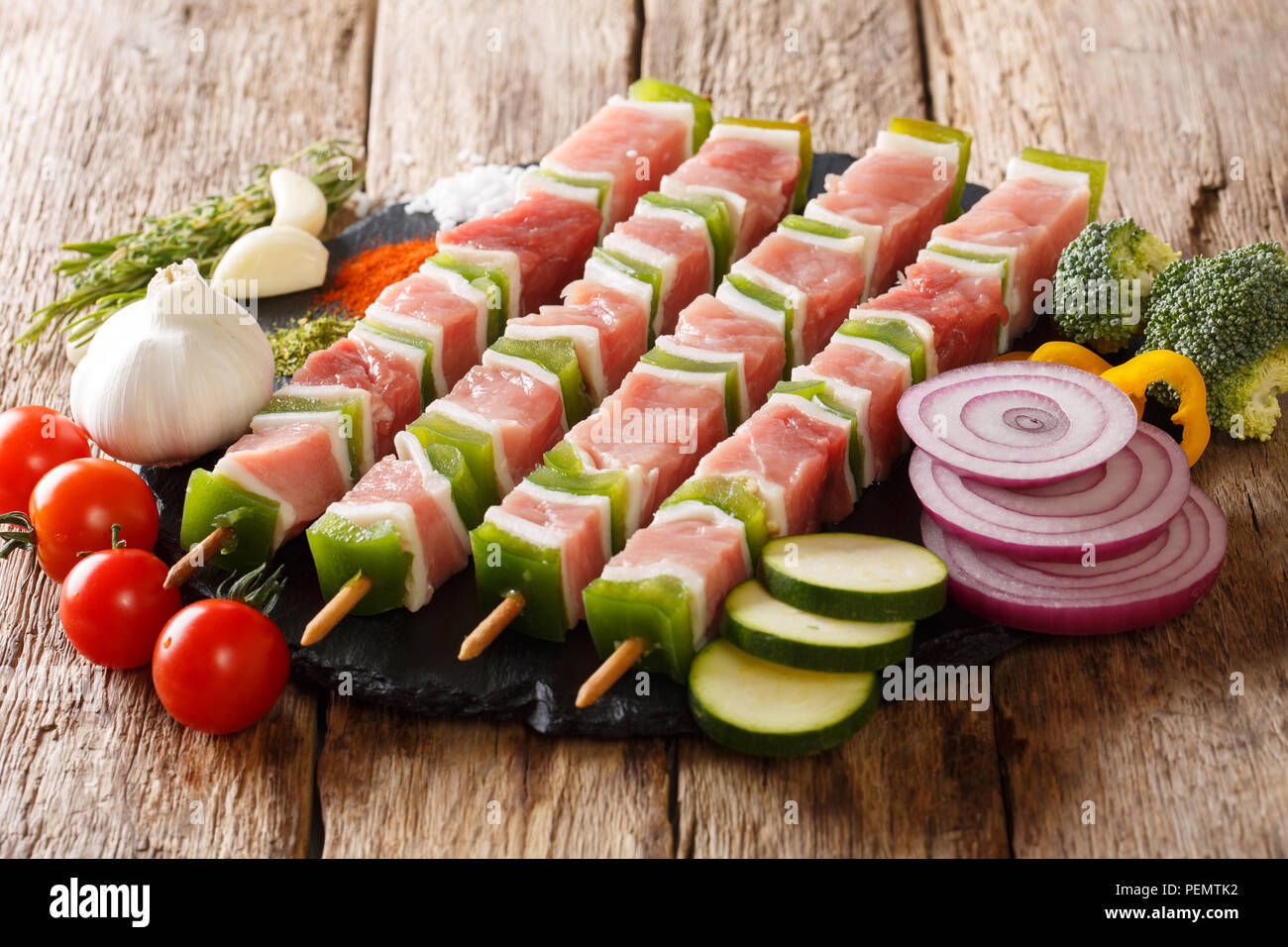 Close up of skewers with juicy meat and vegetables. Raw kebab from pork ...