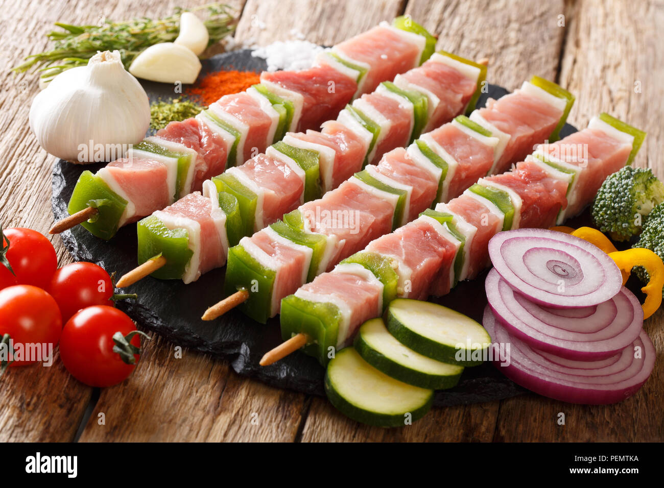 Raw kebab from meat on a wooden background with vegetables close-up ...
